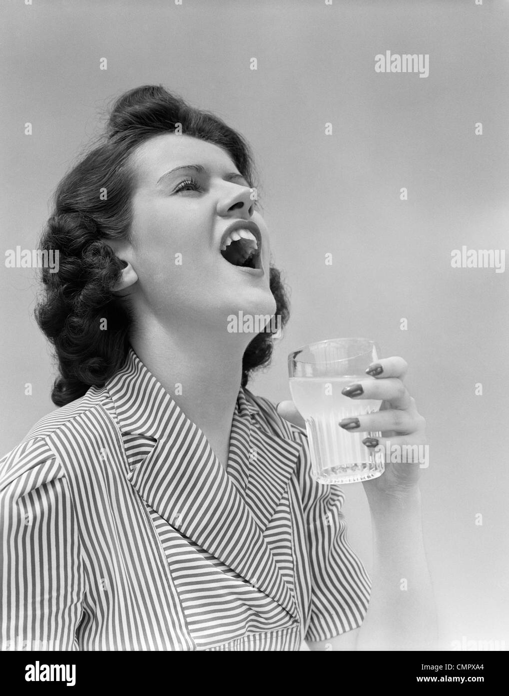 1940s WOMAN GARGLING HOLDING A GLASS Stock Photo - Alamy