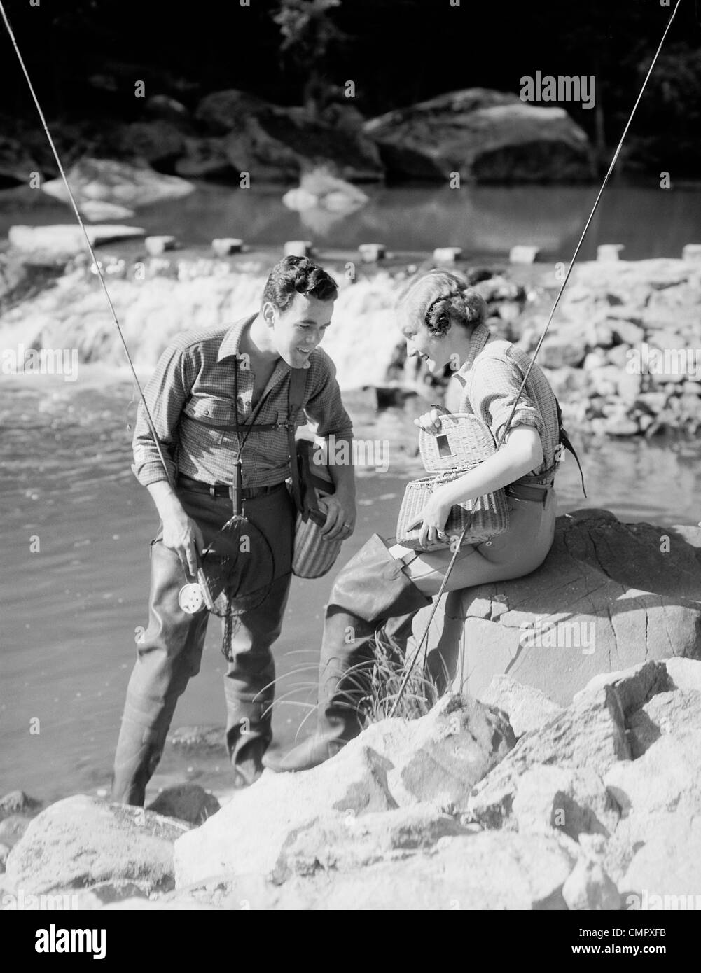 1930s MAN WOMAN IN WADERS FLY FISHING BY STREAM Stock Photo - Alamy
