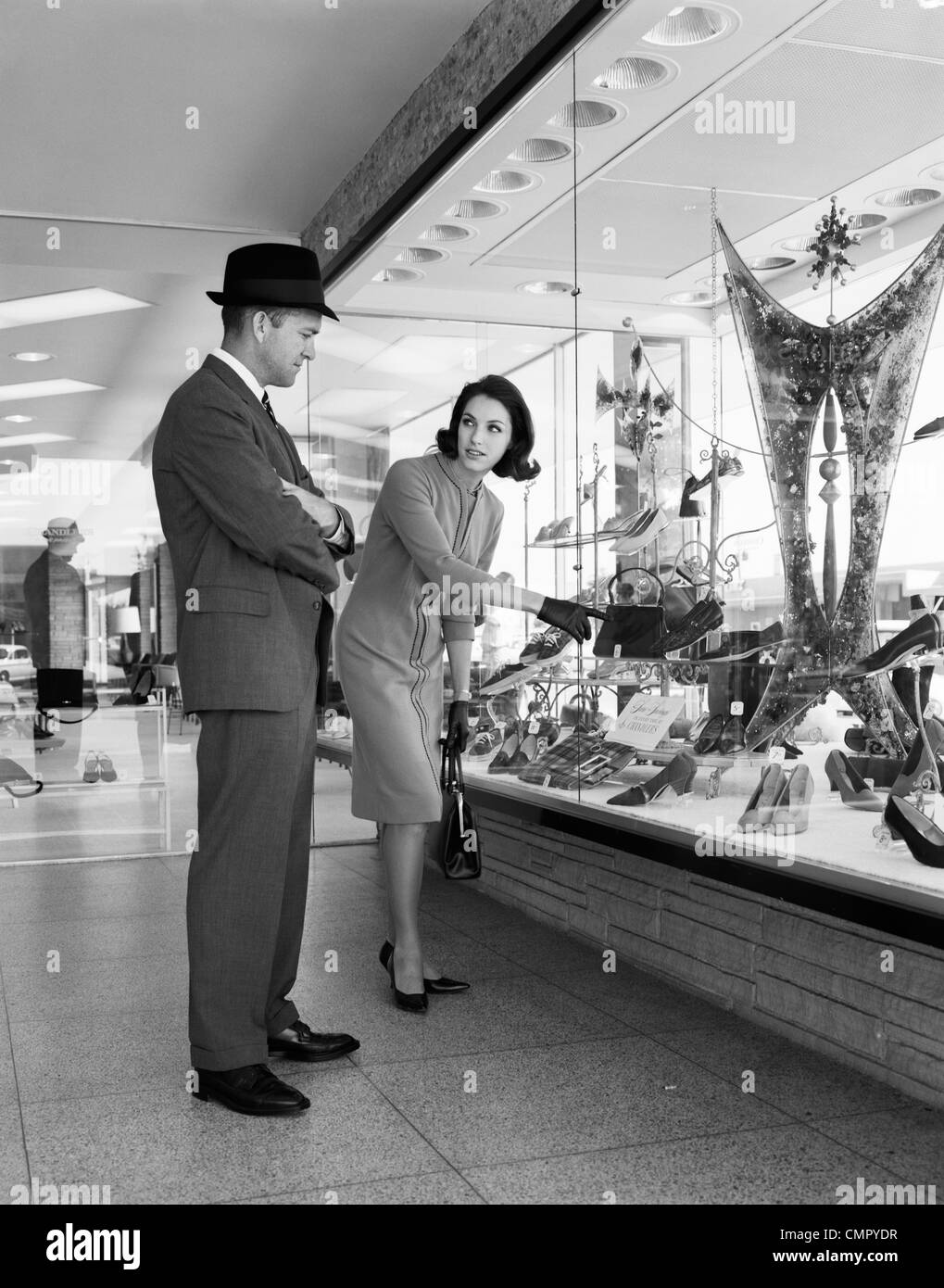1950s COUPLE MAN WOMAN WINDOW SHOPPING WOMAN POINTING TO PAIR OF SHOES ...