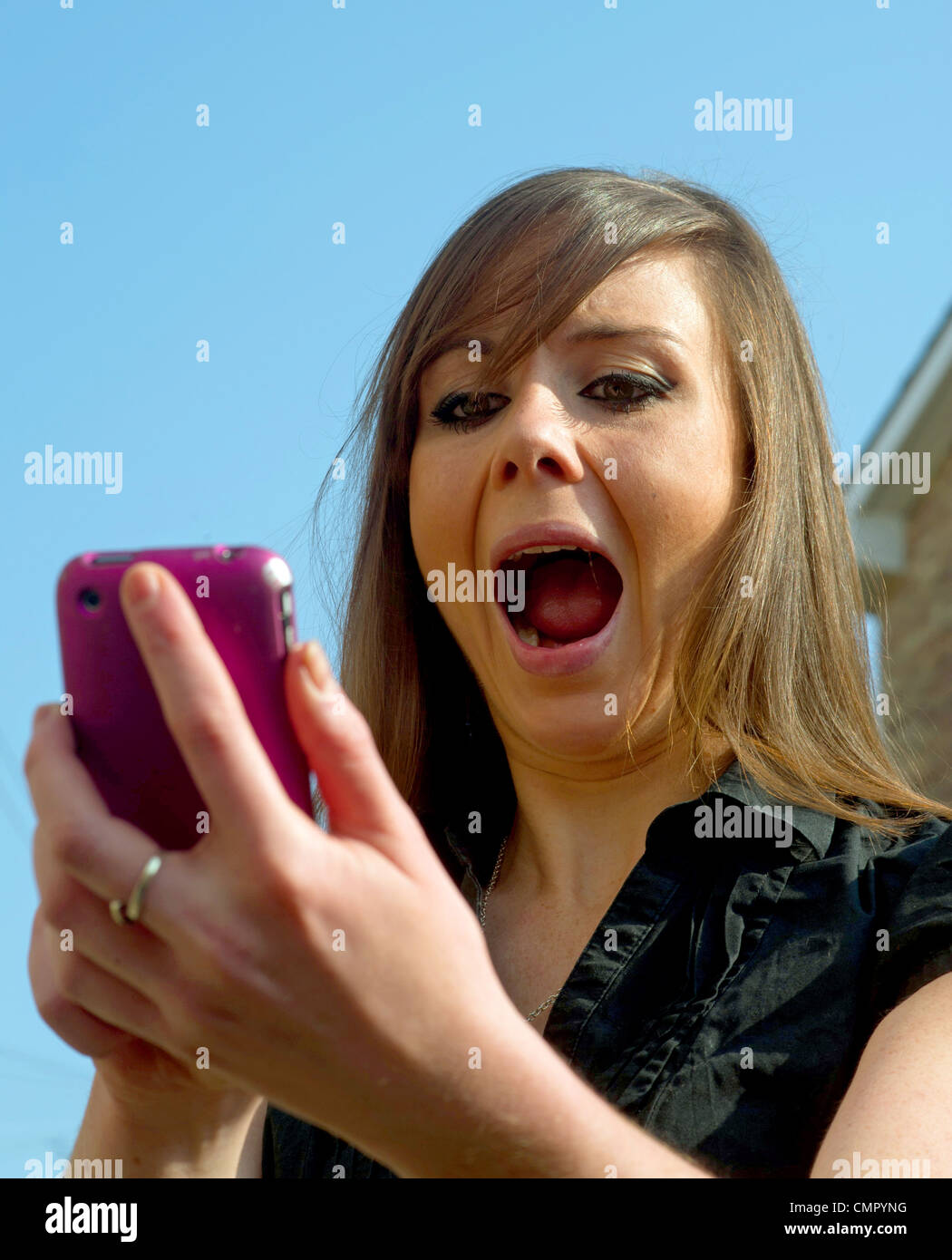 Young woman 20s twentys age group using her pink Apple IPhone looking ...