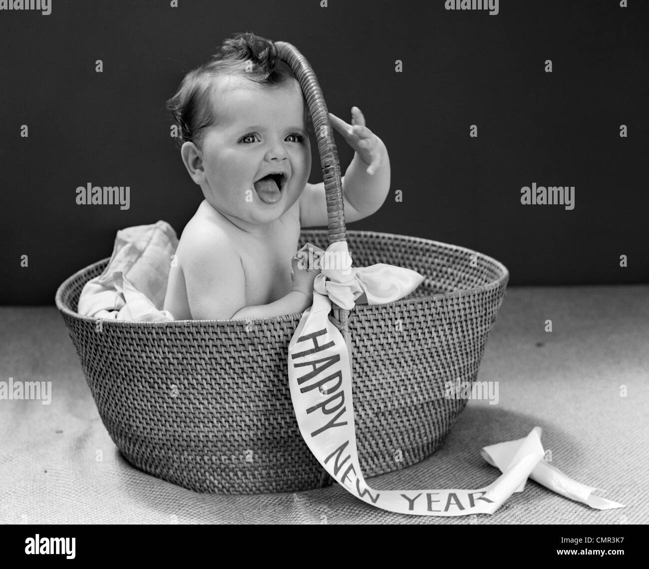 1940s BABY SITTING IN WICKER BASKET WITH HAPPY NEW YEAR BANNER STUDIO ...