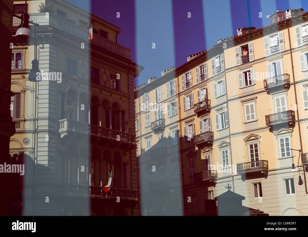 Travel shop window reflection shows the streets of Turin bathed in ...