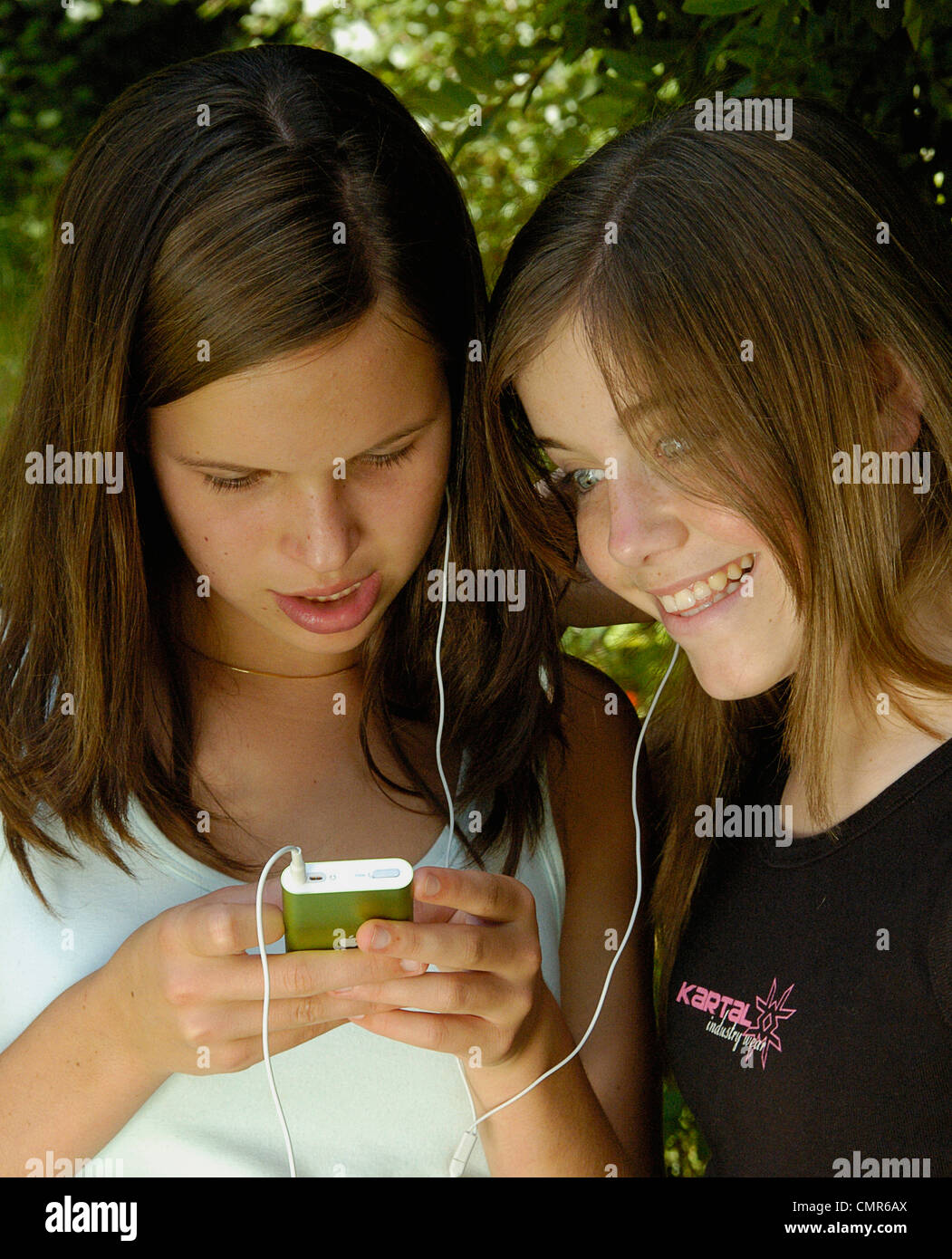 Teenage girls sharing MP3 music on an iPod clone Stock Photo - Alamy