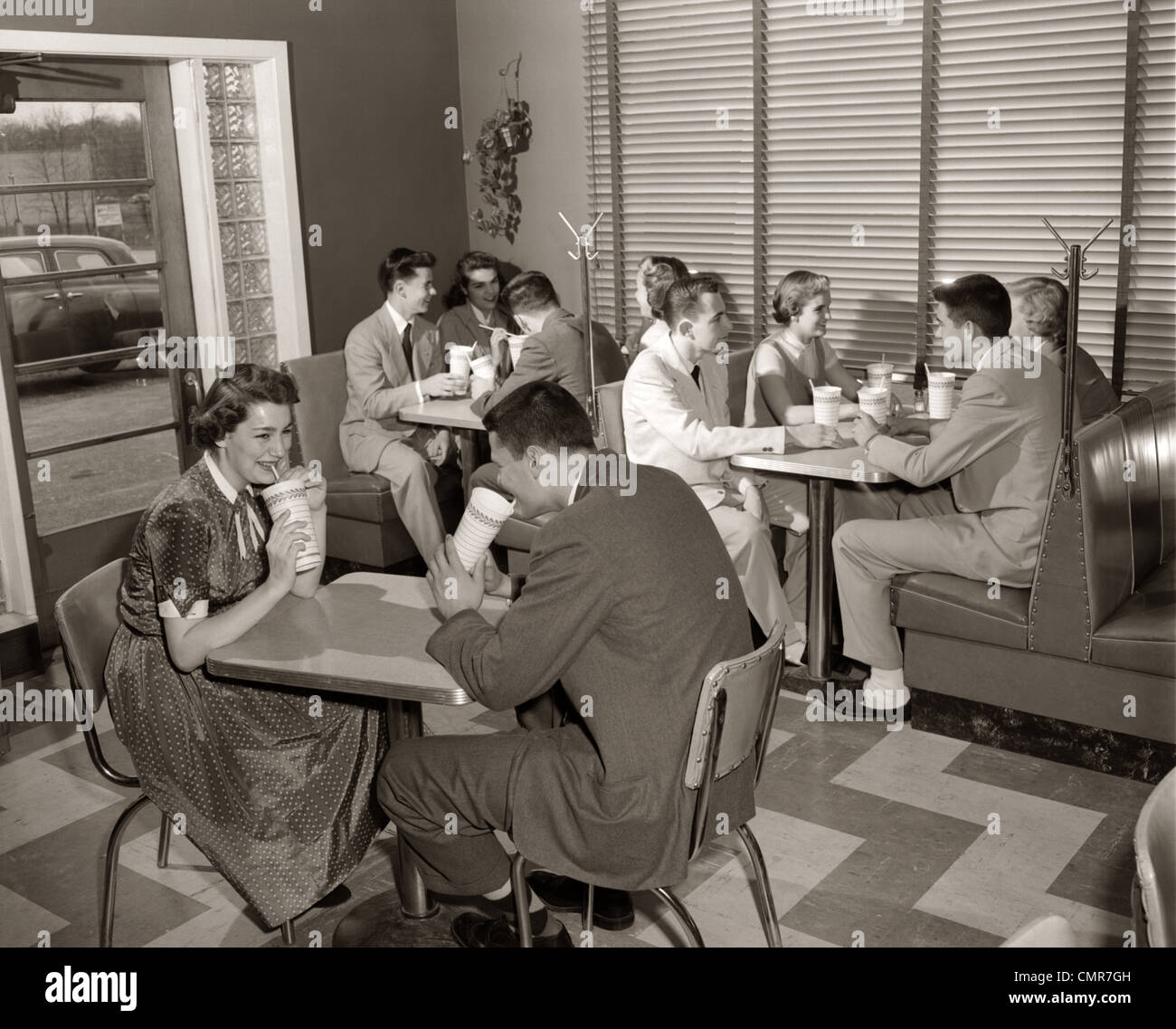 1950s MALT SHOP INTERIOR WITH TEENS AT BOOTHS DRINKING FROM DIXIE CUPS ...