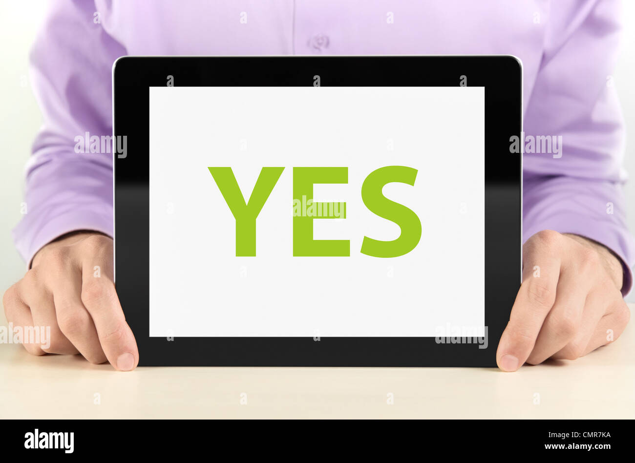 Manager holding tablet pc with "YES" text on screen Stock Photo - Alamy