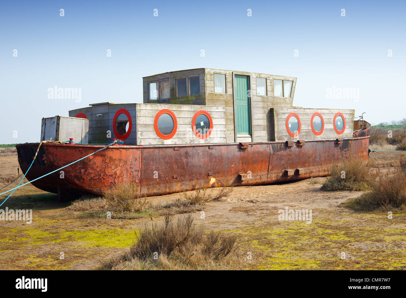 A converted barge made into a houseboat sitting high and dry on a ...