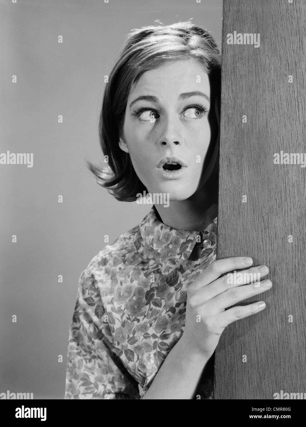 Woman peeking around corner hi-res stock photography and images - Alamy