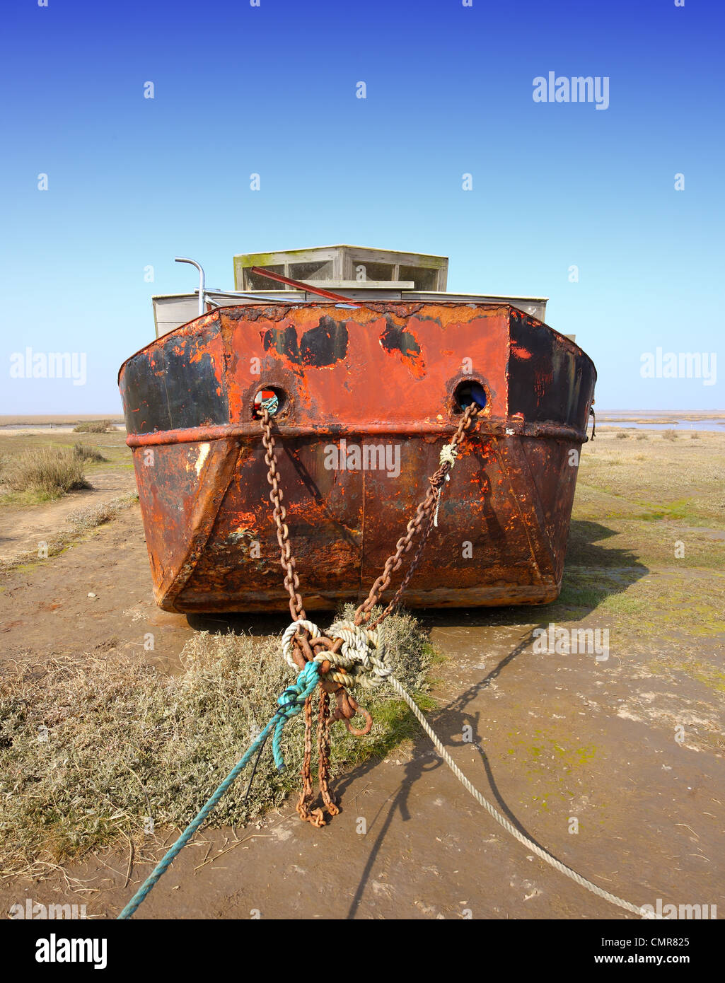 A converted barge made into a houseboat sitting high and dry on a ...
