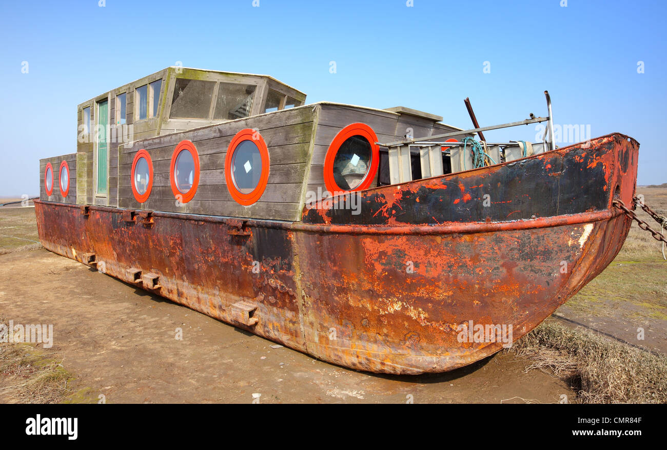 A converted barge made into a houseboat sitting high and dry on a ...