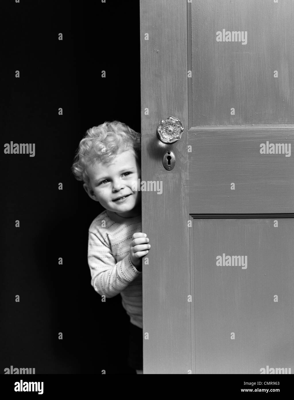 1940s CHILD LITTLE BOY PEEKING LOOKING AROUND DOOR Stock Photo - Alamy