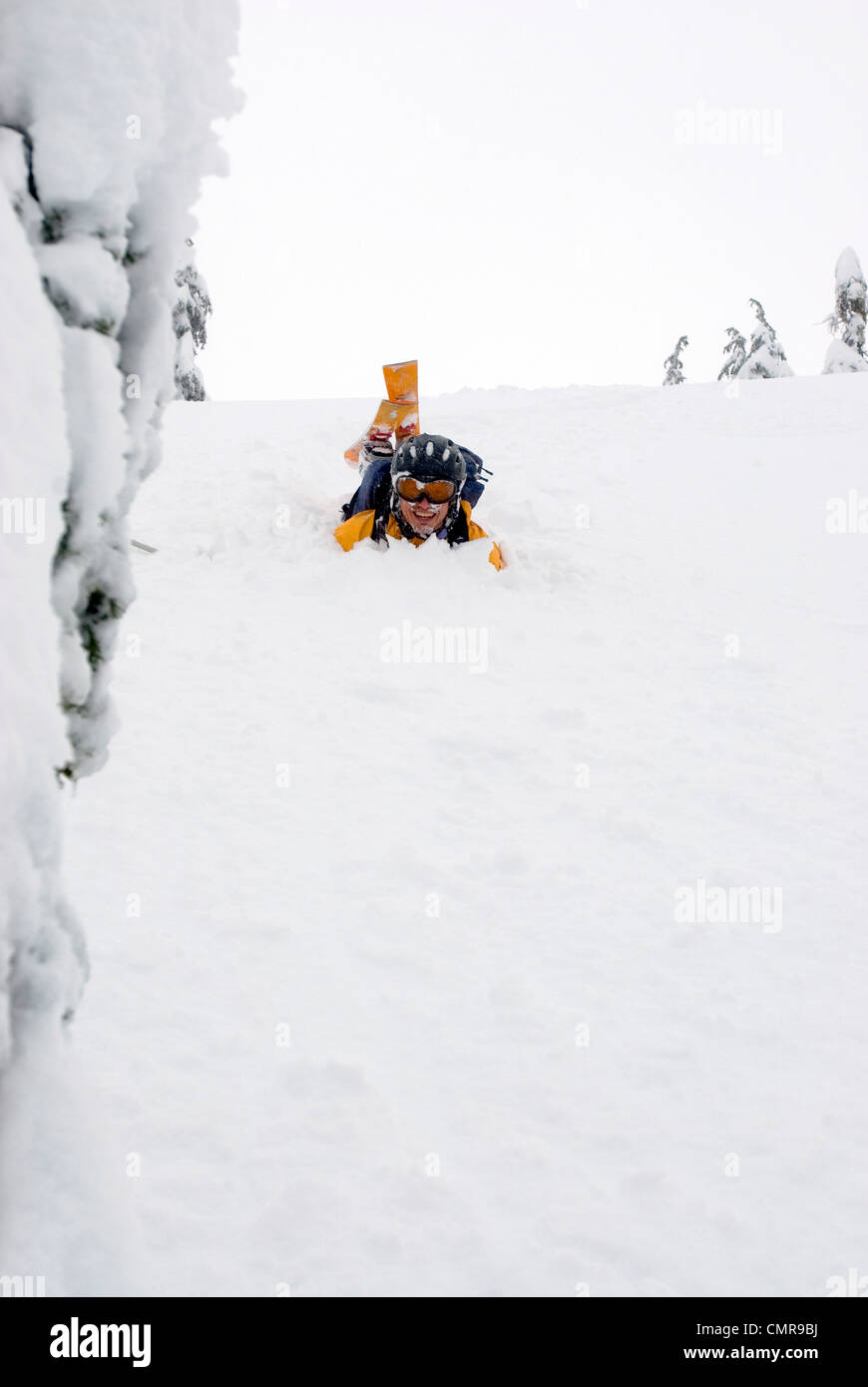 Man laughing in the snow after falling while skiing, Lago Peak in the ...