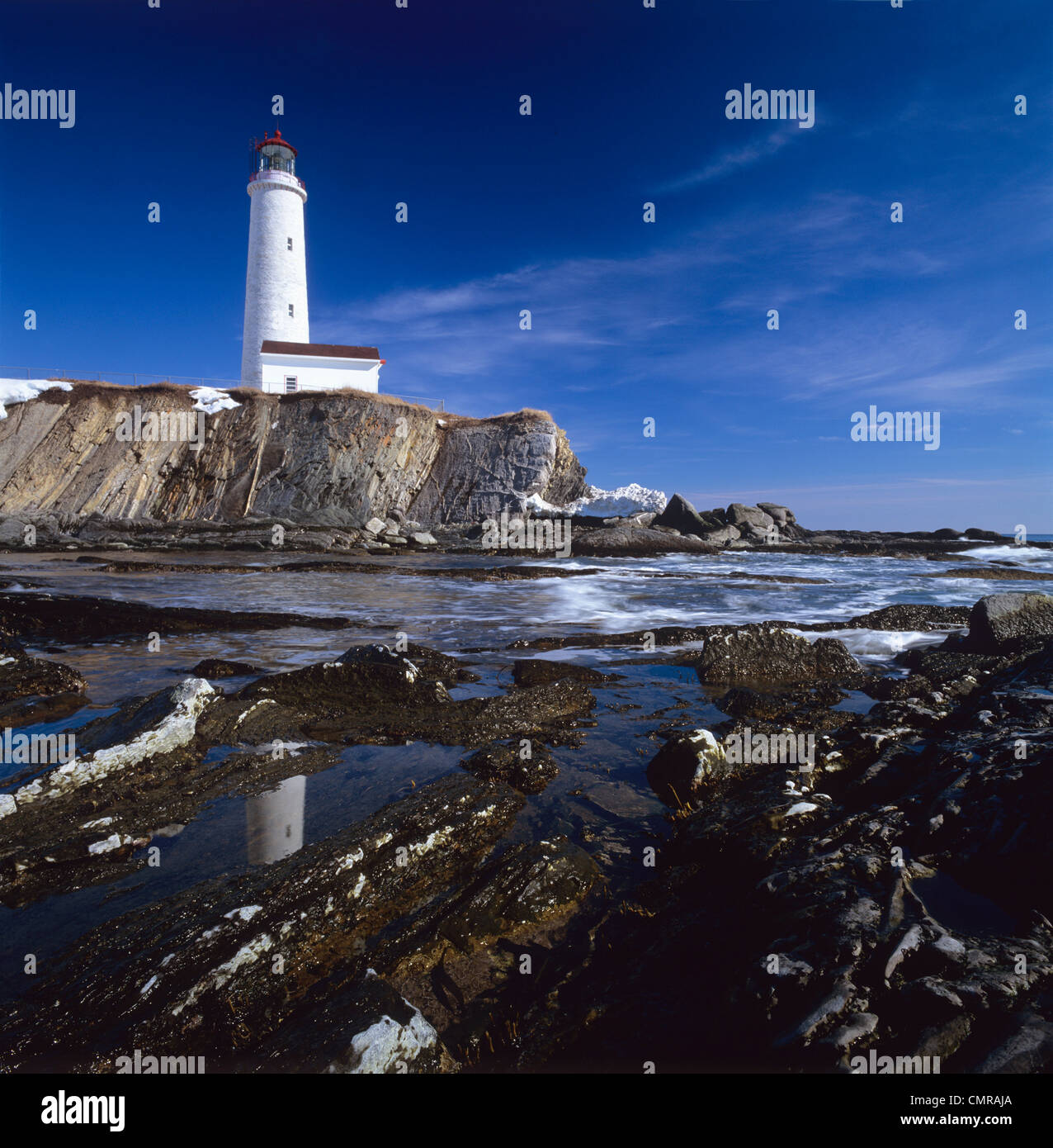 Lighthouse by a rocky shore, Cap-des-Rosiers, Gaspe Coast, Quebec Stock ...