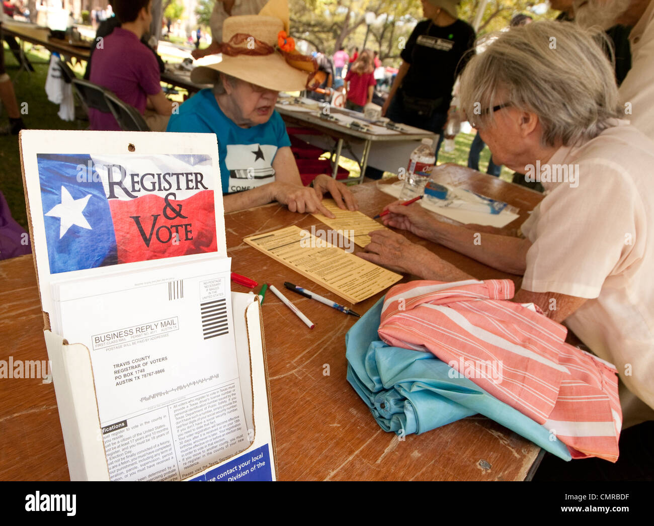 Female worker tends to a voter registration table trying to lure ...