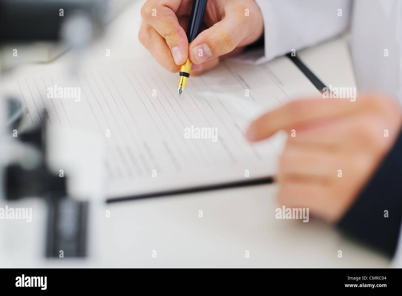 Closeup writing in document hands of medical doctor Stock Photo - Alamy