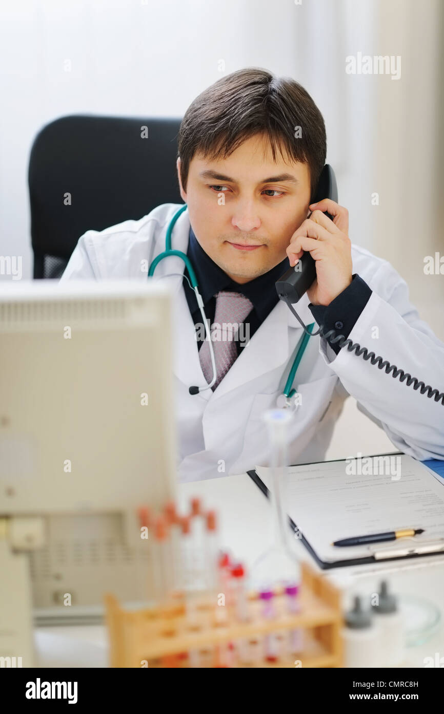 Medical doctor speaking phone at office Stock Photo - Alamy