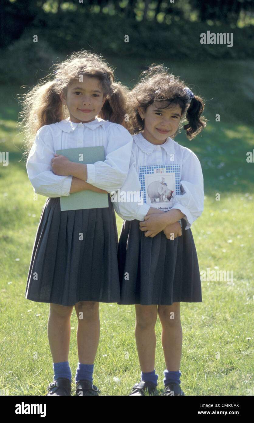 two little schoolgirls holding books Stock Photo - Alamy