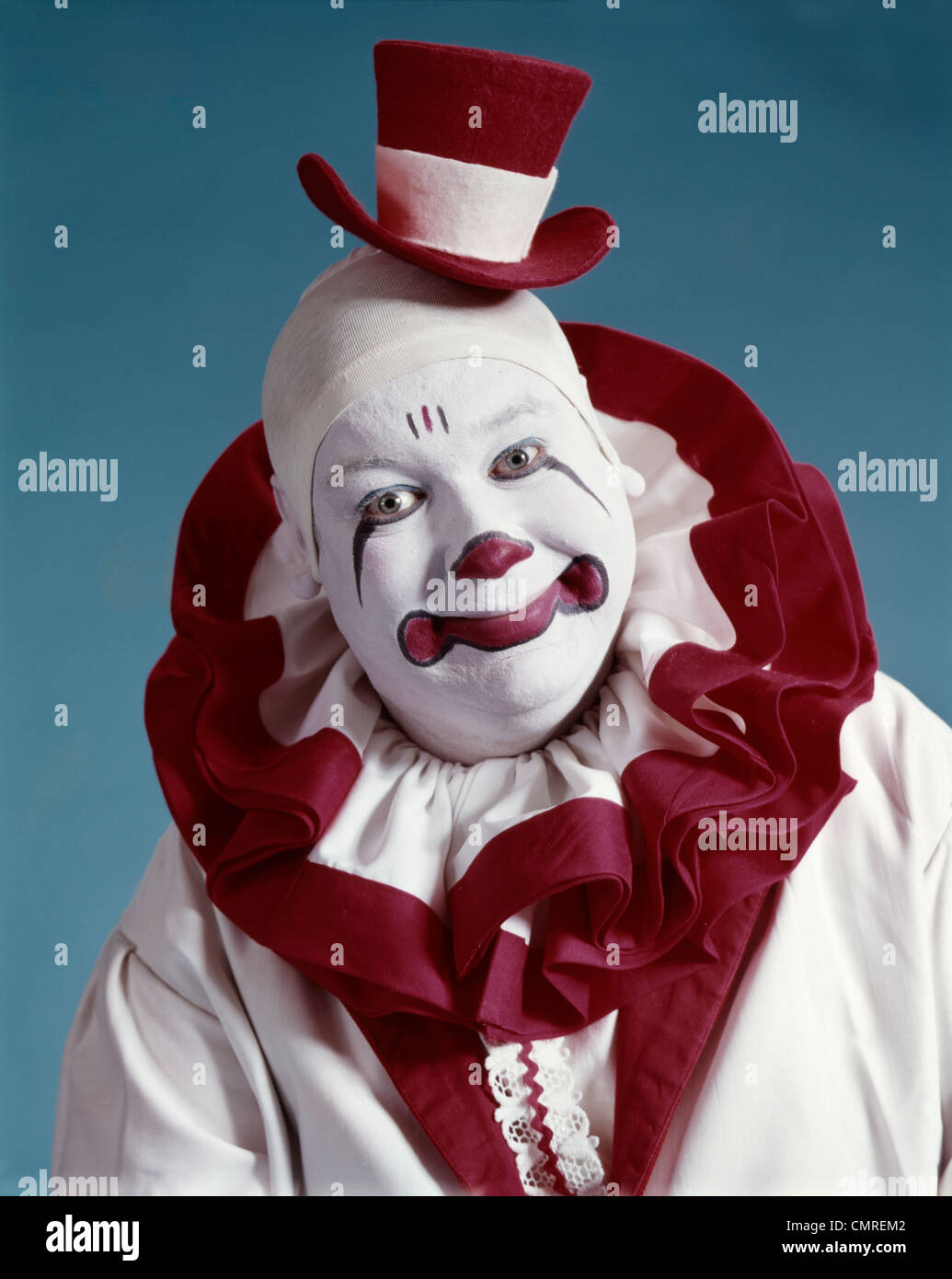 1970s PORTRAIT OF CIRCUS CLOWN IN RED AND WHITE COSTUME LOOKING AT ...