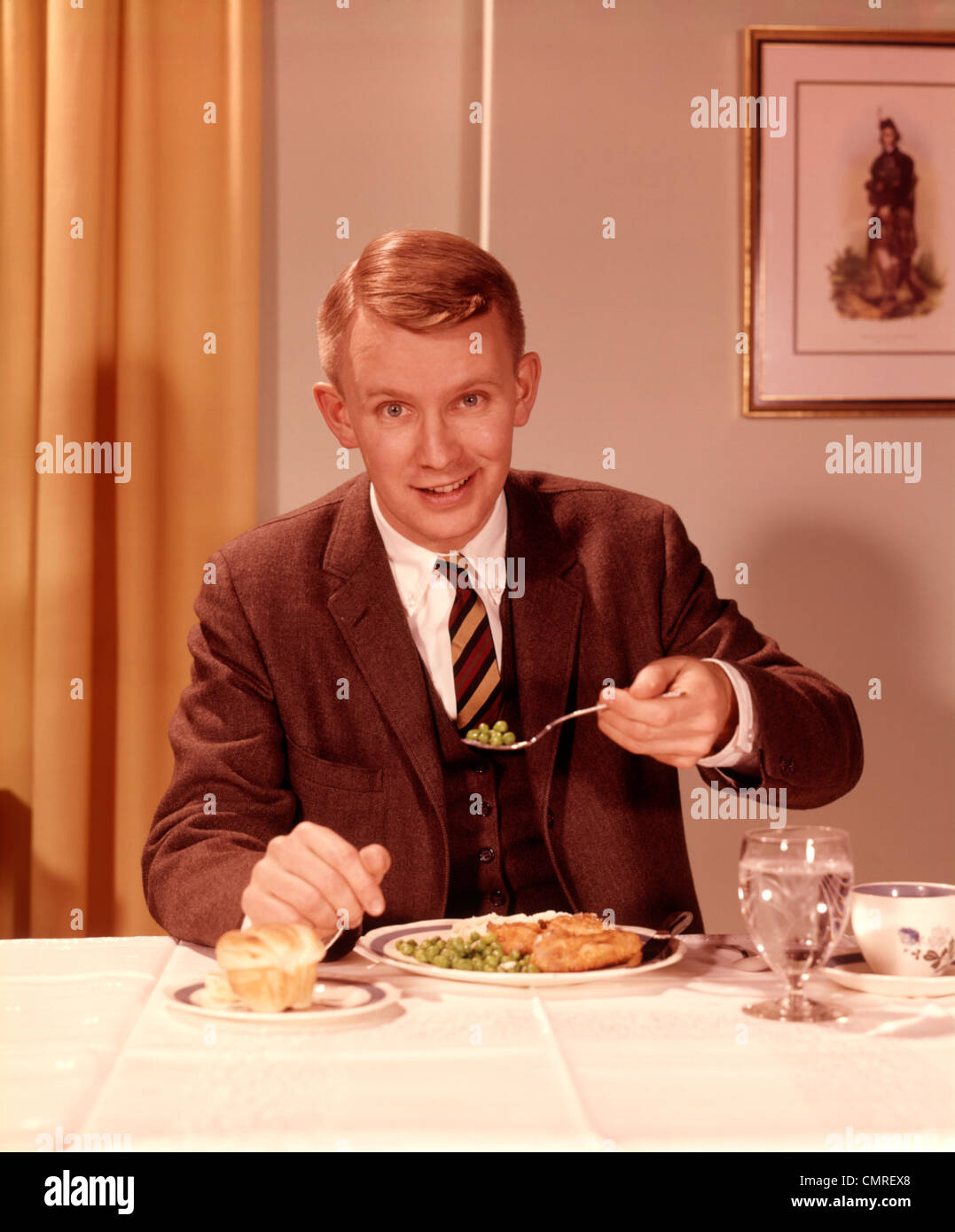 1960s SMILING MAN EATING DINNER AT TABLE WITH FORK FULL OF PEAS Stock ...