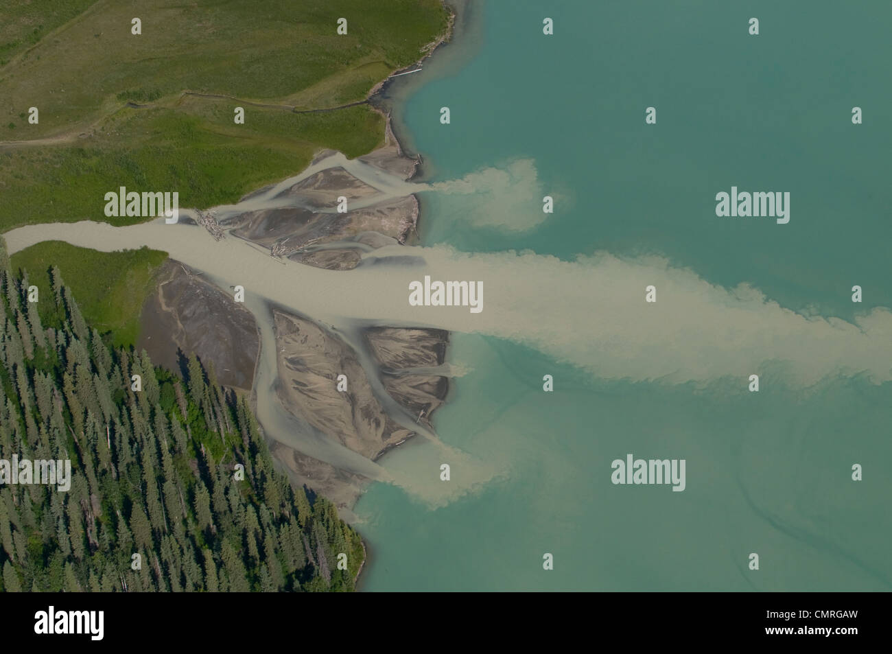 Aerial view of glacial creek flowing into green waters of Glacier Lake ...