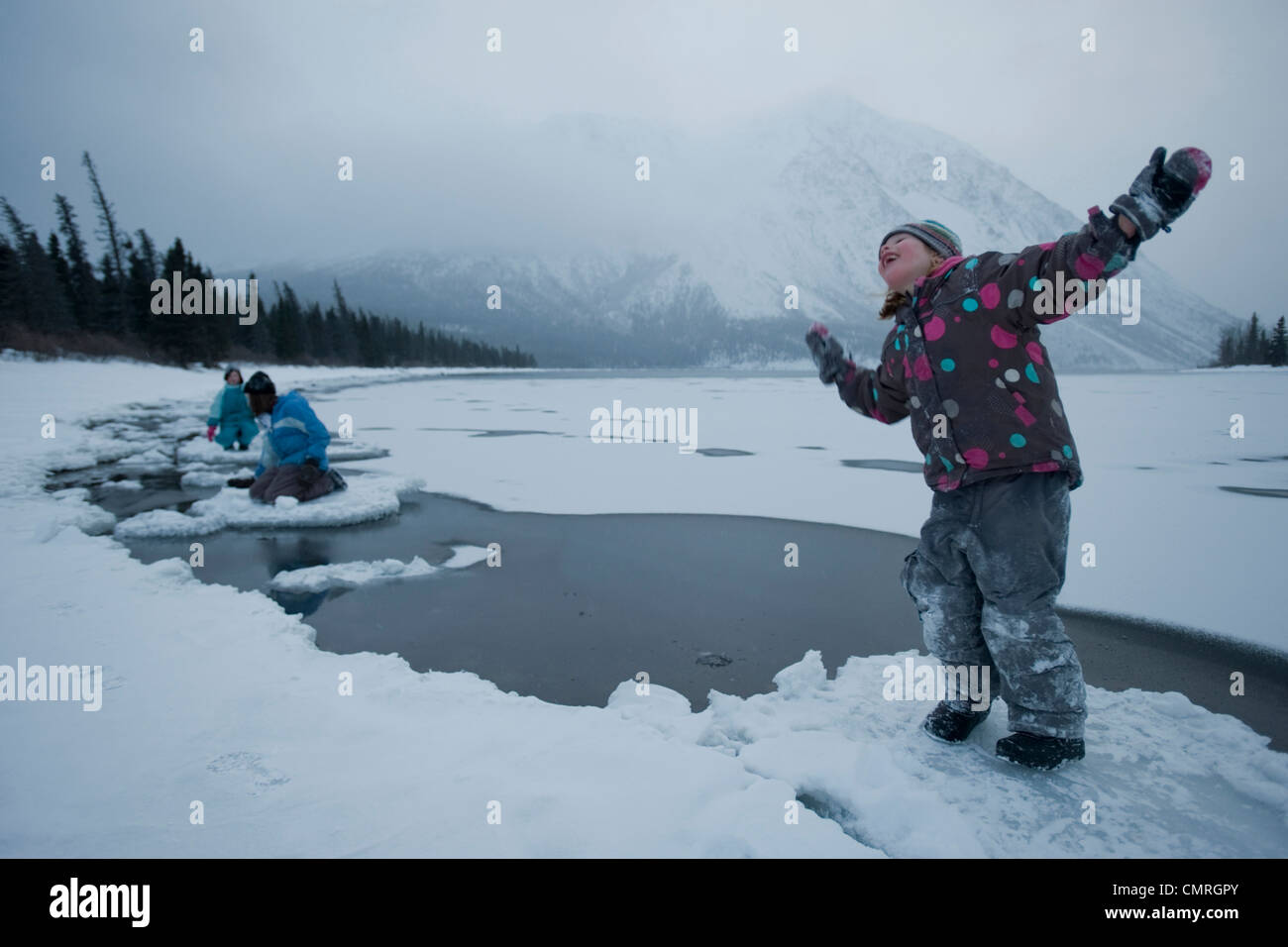 Happy girl on ice floe of freezing lake, Kathleen Lake, Kluane National ...