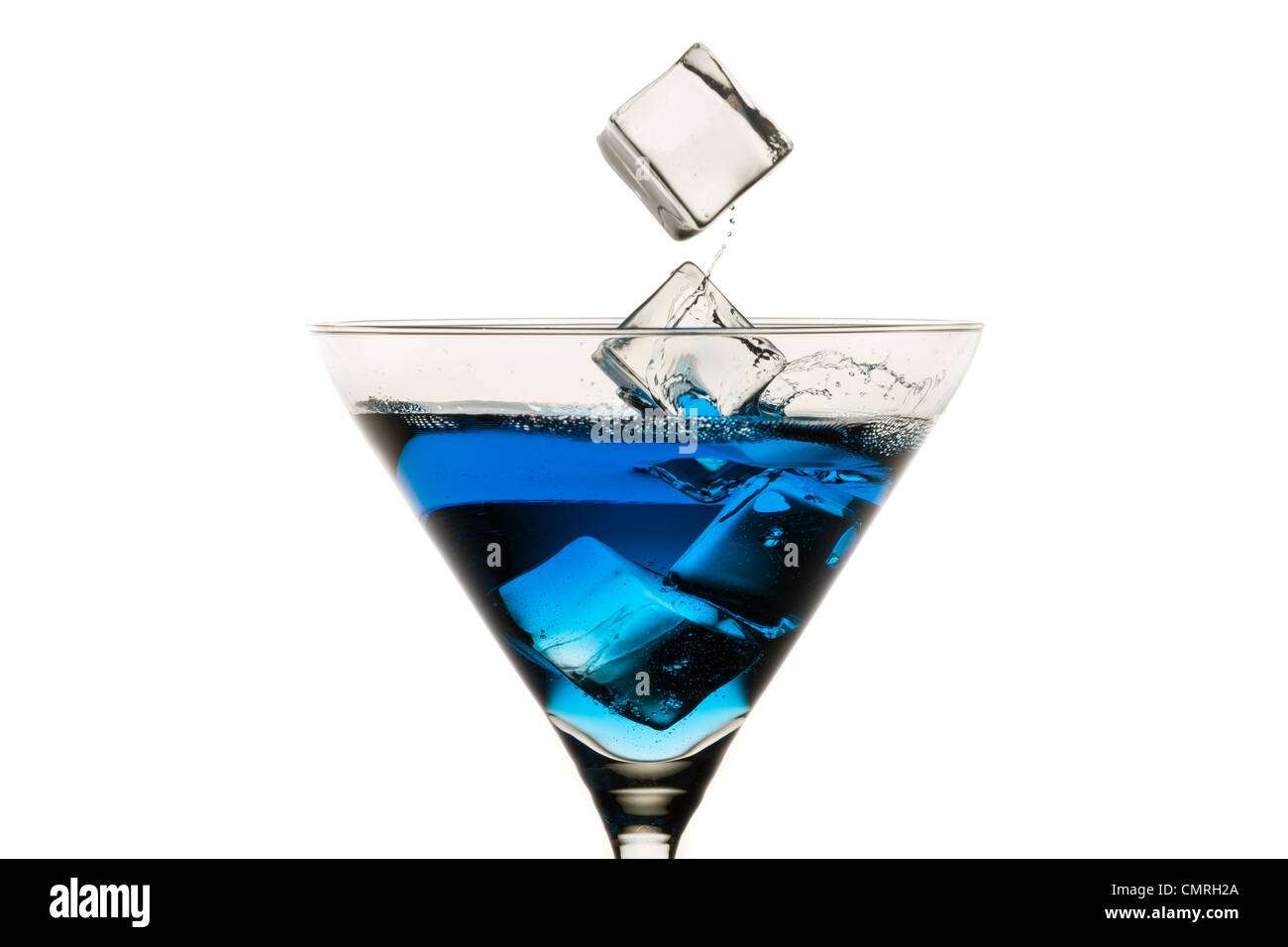 Dropping ice cubes into martini glasses on white background Stock Photo - Alamy