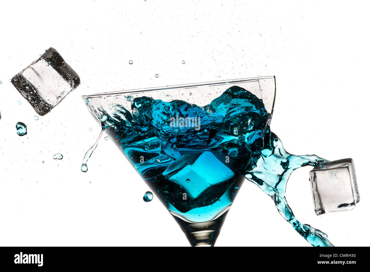 Ice cubes breaking martini glass filled with blue liqueur on white background Stock Photo - Alamy