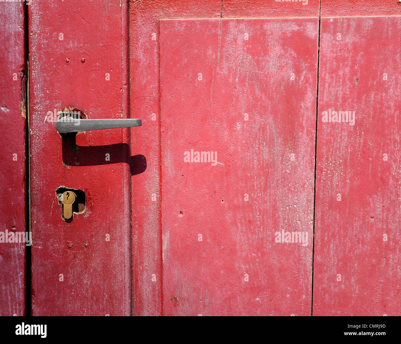 Part of old red wooden door with metal handle Stock Photo - Alamy