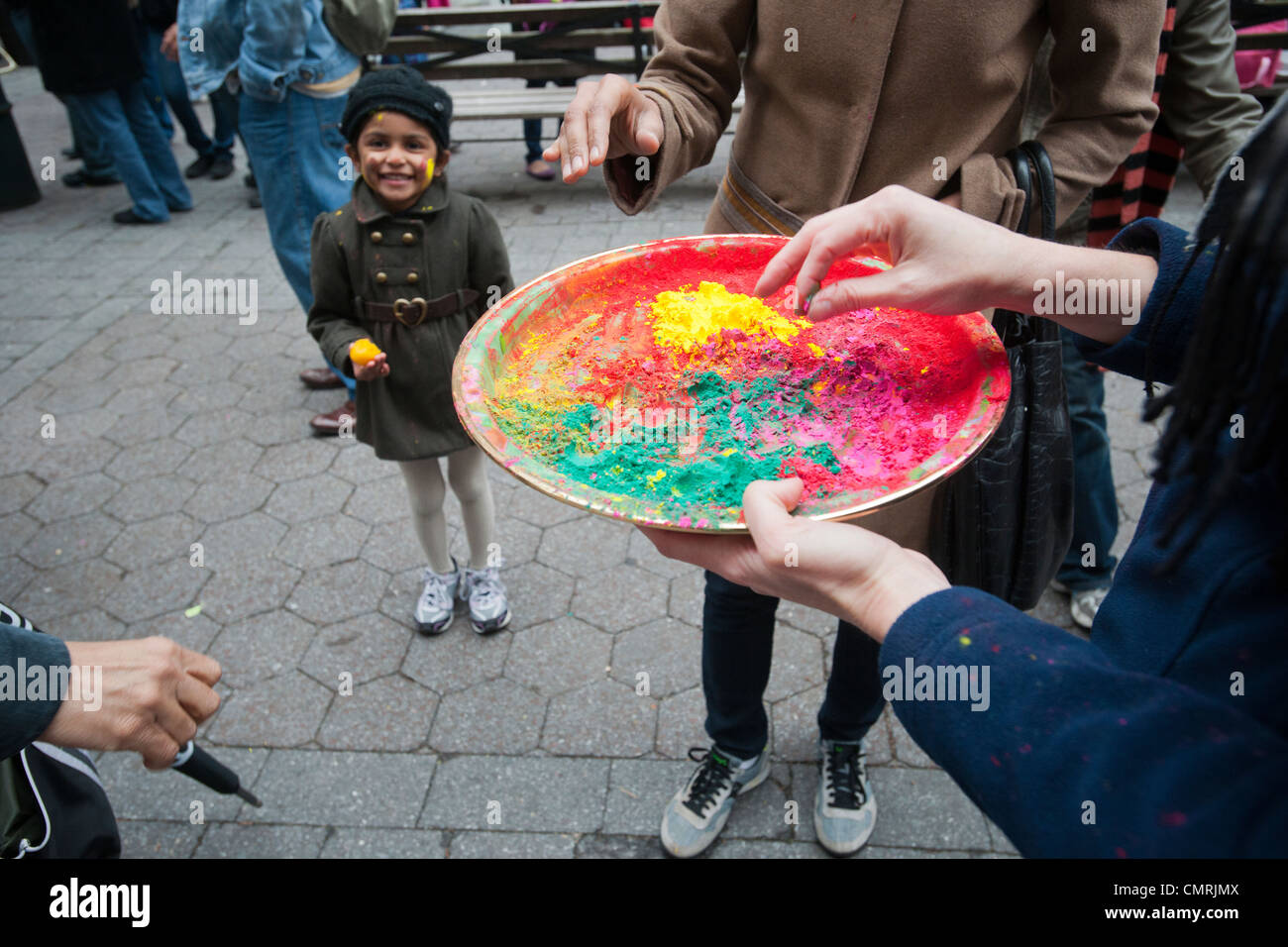 Colored powder is applied to the faces of participants as they ...