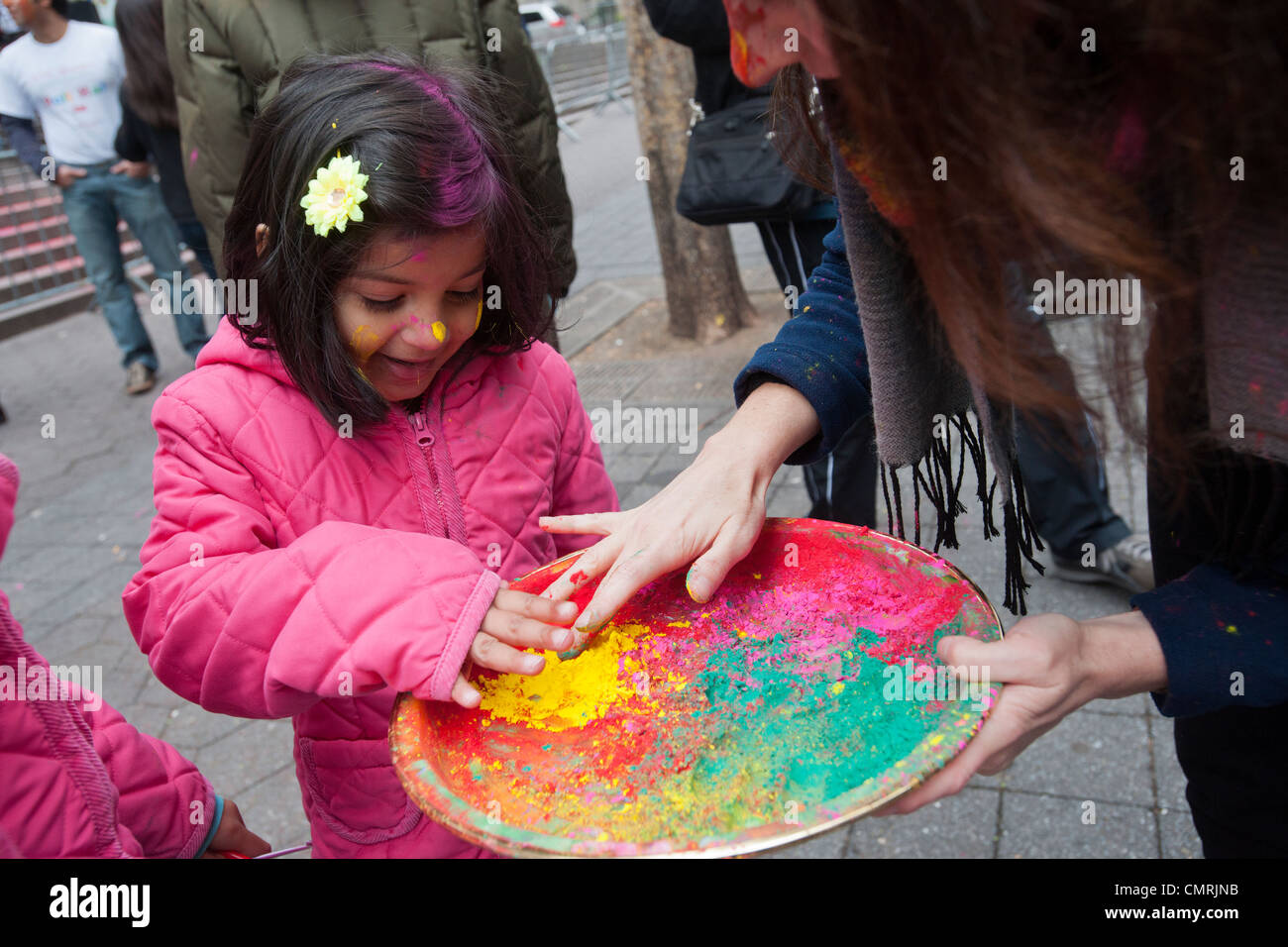 Colored powder is applied to the faces of participants as they ...