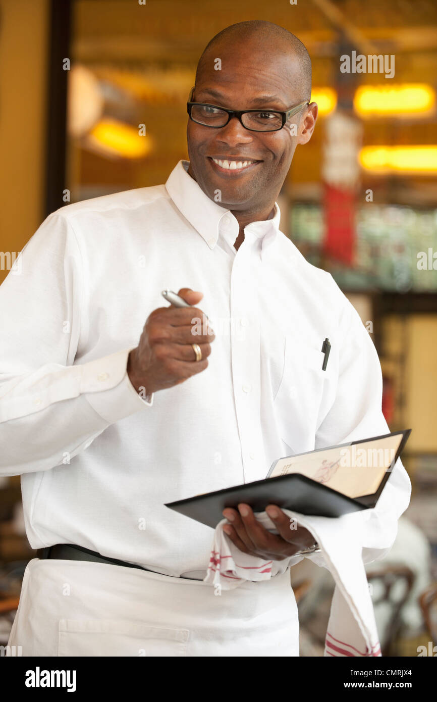 African American waiter holding order pad in restaurant Stock Photo - Alamy
