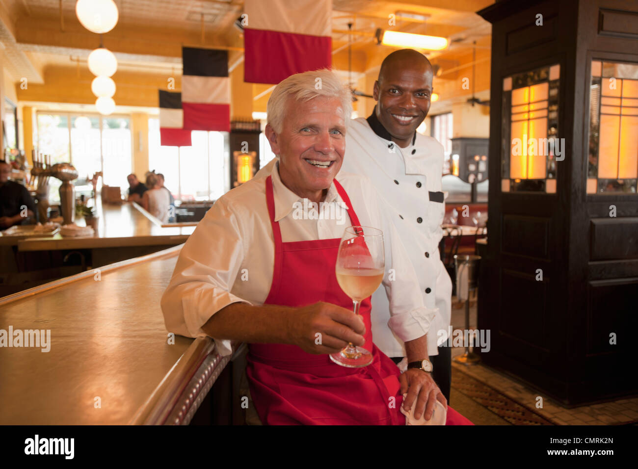 Smiling restaurant waiter and chef Stock Photo - Alamy