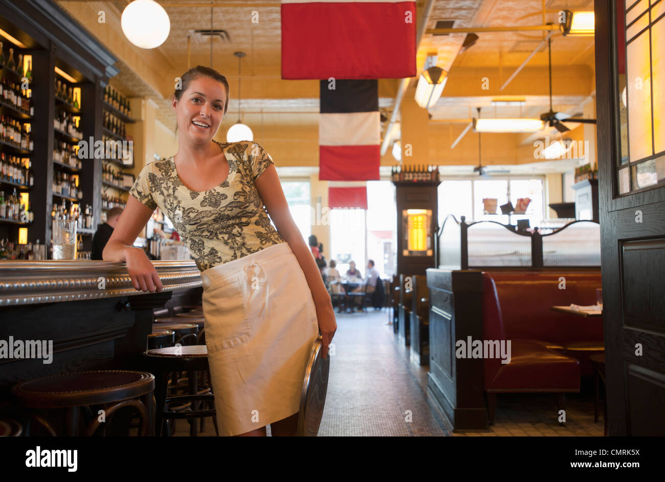 Caucasian waitress leaning on bar in restaurant Stock Photo - Alamy