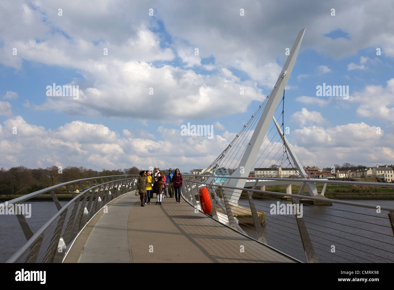 tourists crossing the new peace bridge in Derry city county londonderry ...