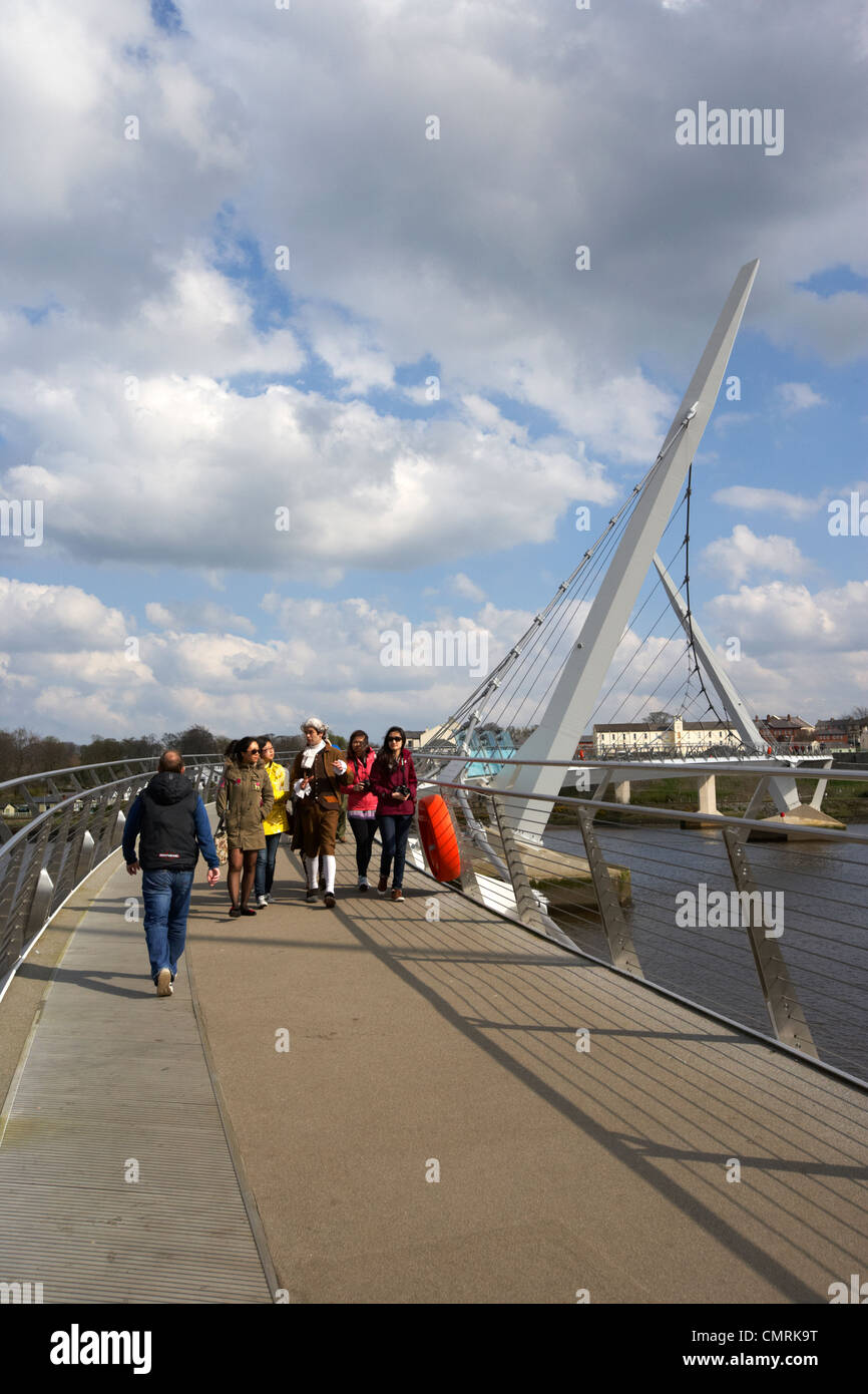 tourists crossing the new peace bridge in Derry city county londonderry ...