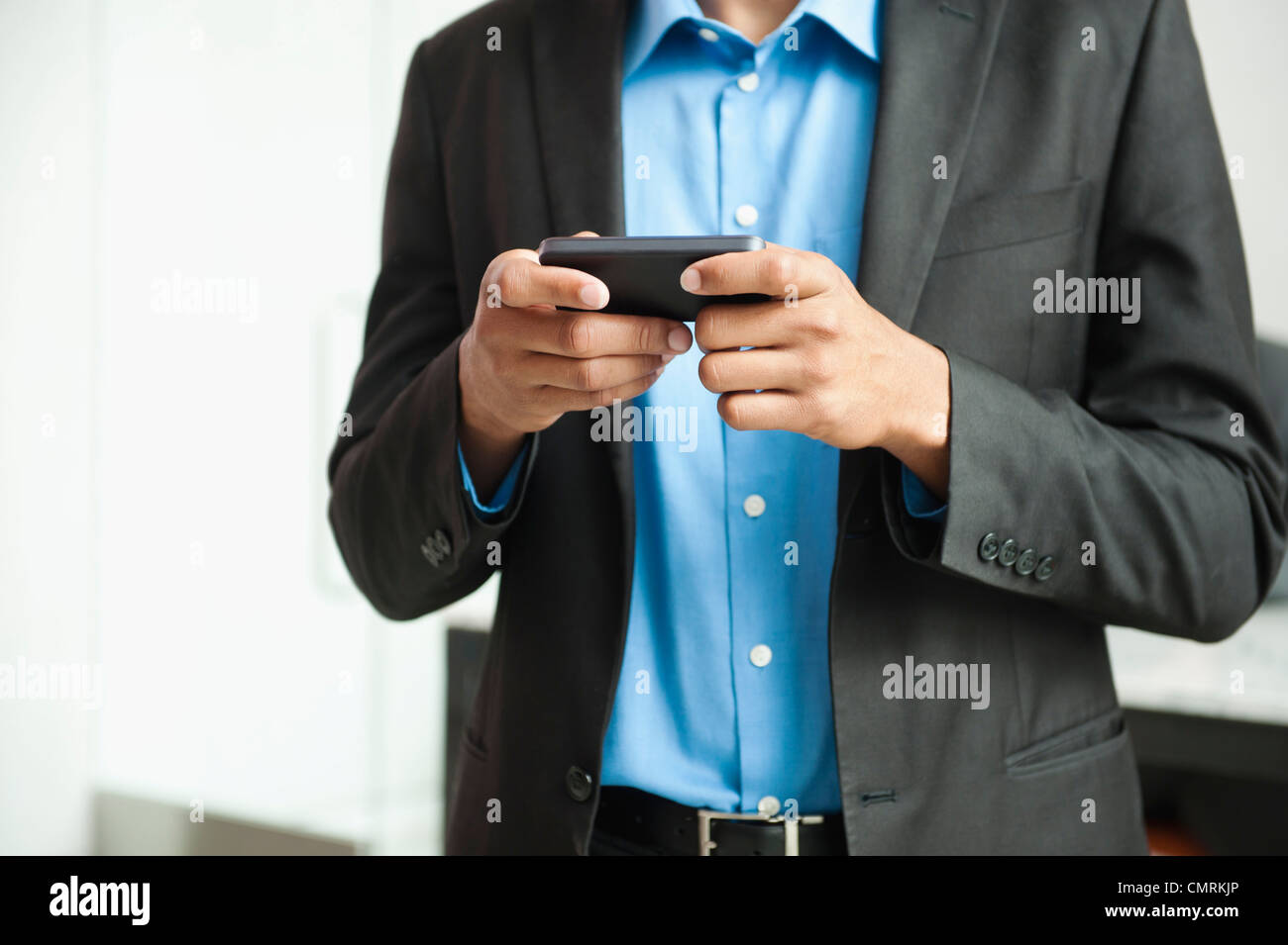 Black businessman text messaging on cell phone Stock Photo - Alamy