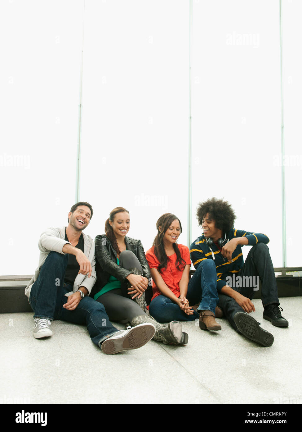 Smiling friends sitting on floor together Stock Photo - Alamy
