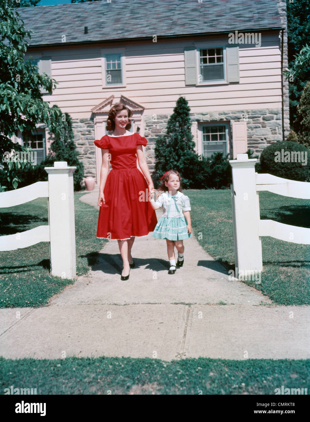MOTHER AND DAUGHTER WALKING OUT GATE FROM SUBURBAN HOUSE OUTDOOR Stock ...