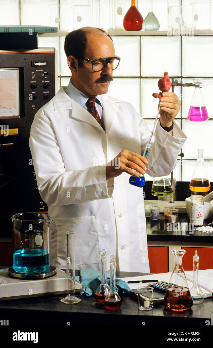 1980s CHEMIST DRAWING BLUE LIQUID OUT OF FLASK Stock Photo - Alamy