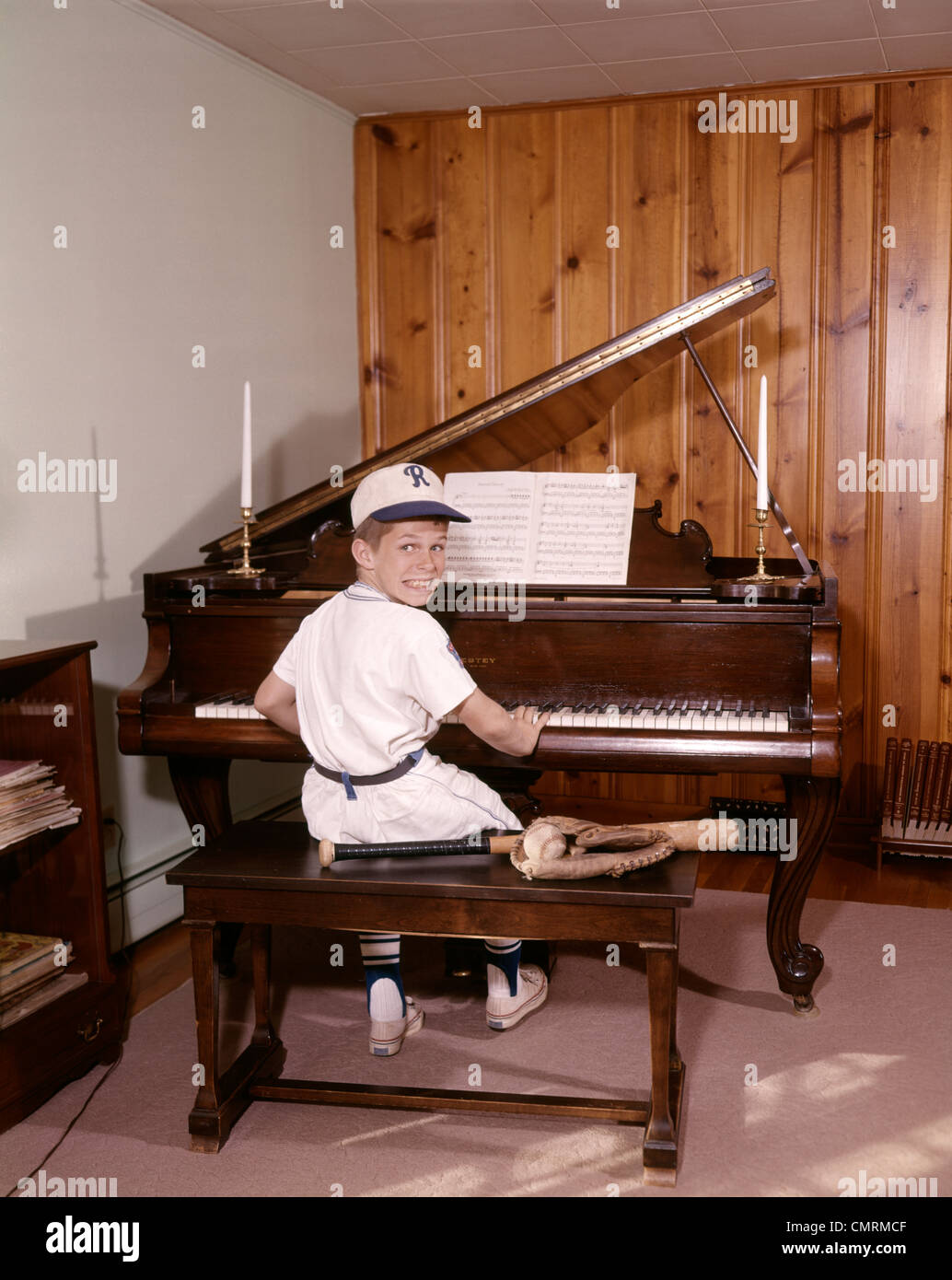 BOY PLAYING PIANO BASEBALL UNIFORM 1970 1970s Stock Photo - Alamy
