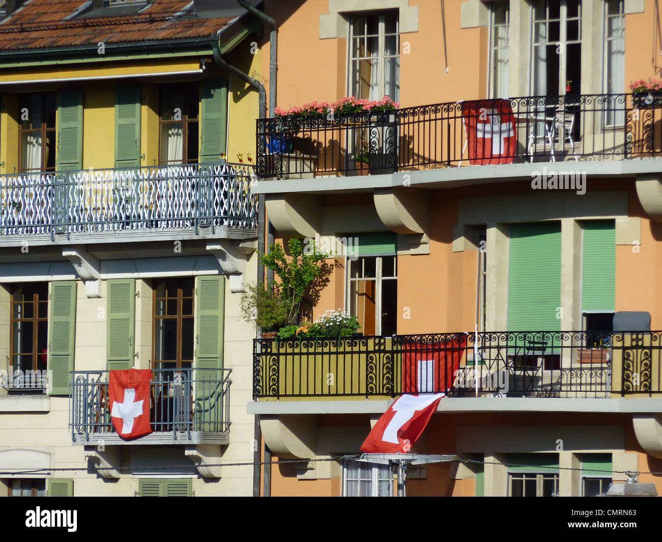 Swiss flags hanging on old building balconies and sunlight, Geneva ...