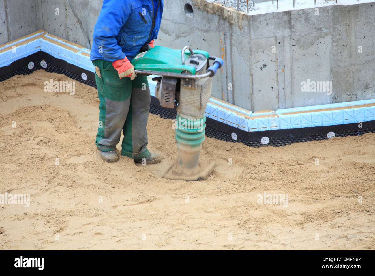 Worker at site working with compress tool - sand Stock Photo - Alamy