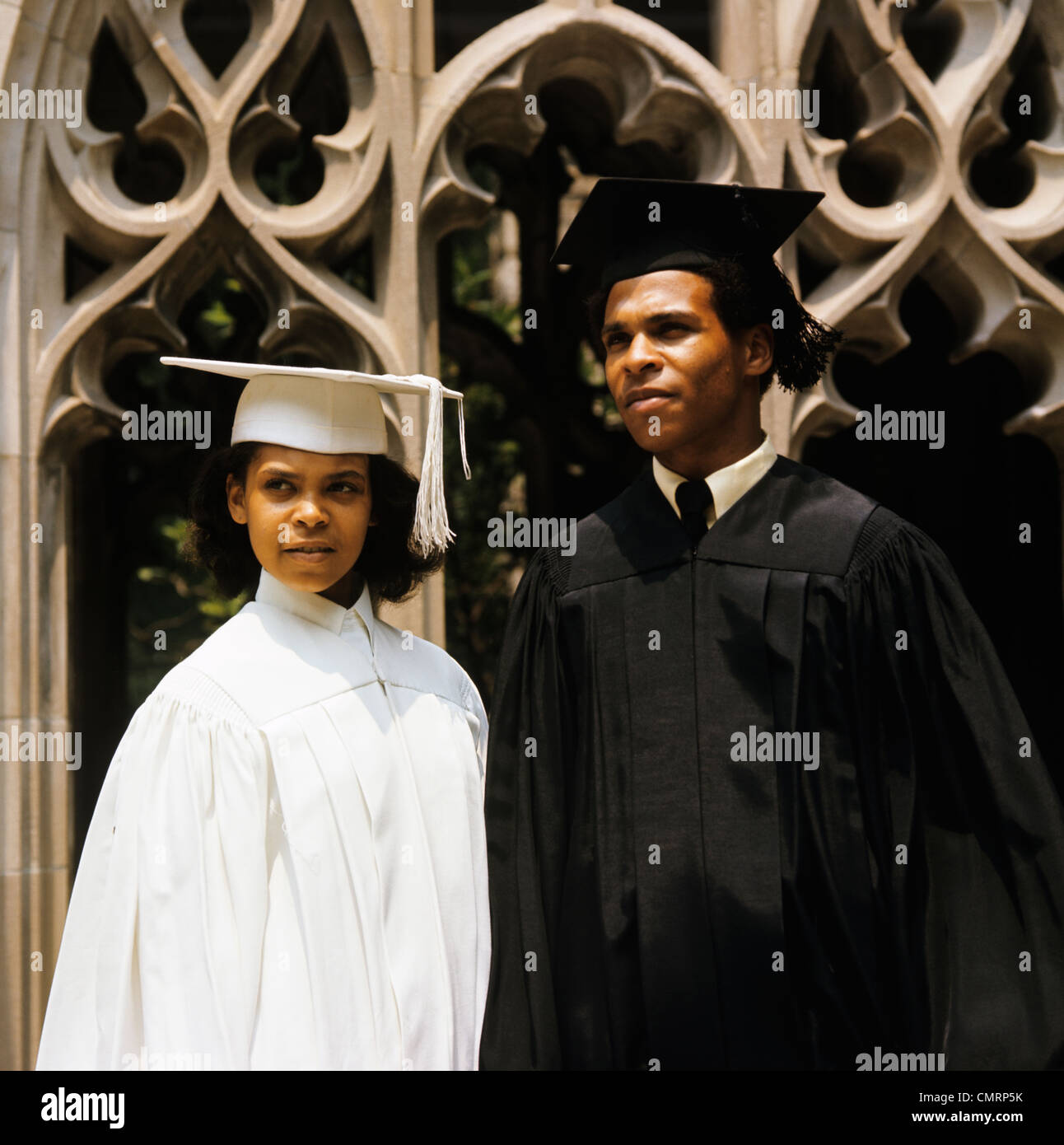 1960s AFRICAN-AMERICAN TEEN BOY AND GIRL WEARING GRADUATION ROBES Stock ...