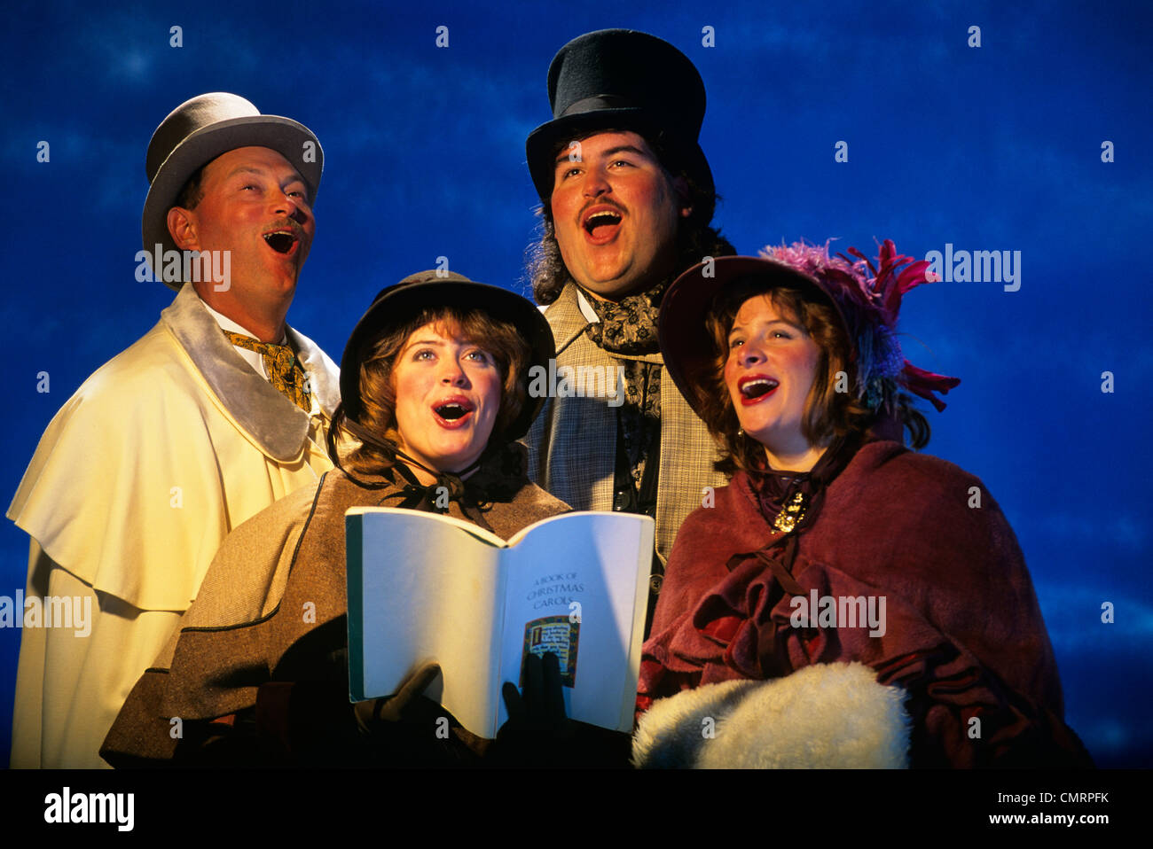 PORTRAIT OF FOUR CHRISTMAS CAROLERS IN PERIOD COSTUMES Stock Photo - Alamy
