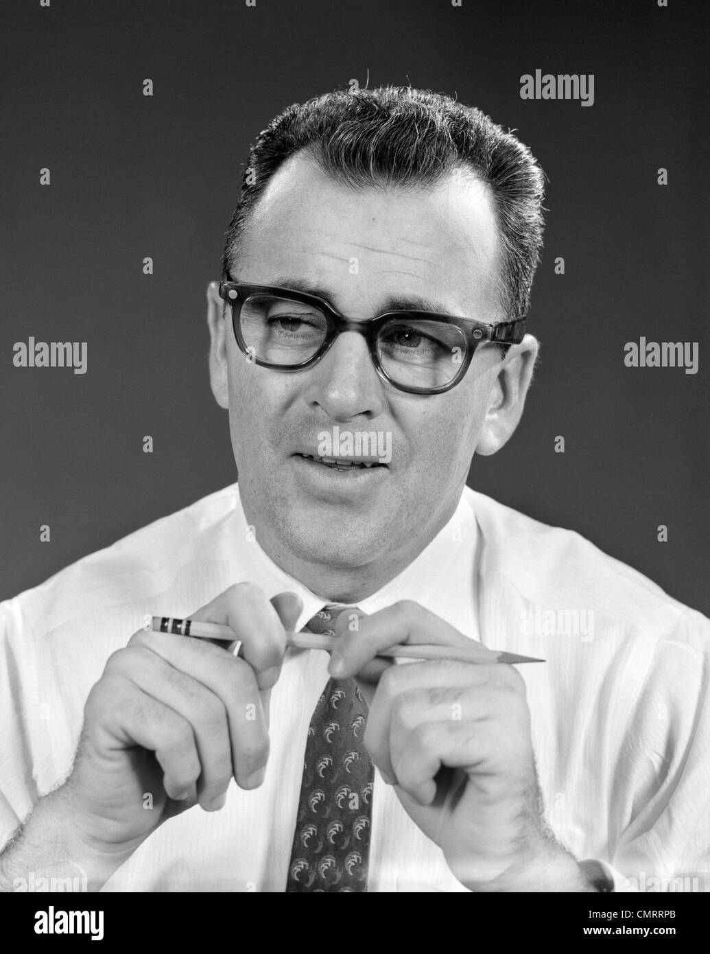 1960s PORTRAIT OF BUSINESSMAN WEARING GLASSES HOLDING PENCIL IN BOTH ... 1960s PORTRAIT OF BUSINESSMAN WEARING GLASSES HOLDING PENCIL IN BOTH ...