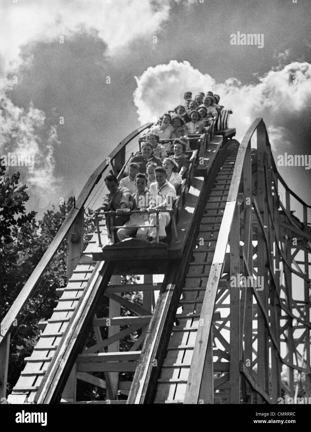 1950s GROUP OF TEENS ON ROLLER COASTER COMING DOWN TOP OF CREST OUTDOOR ...
