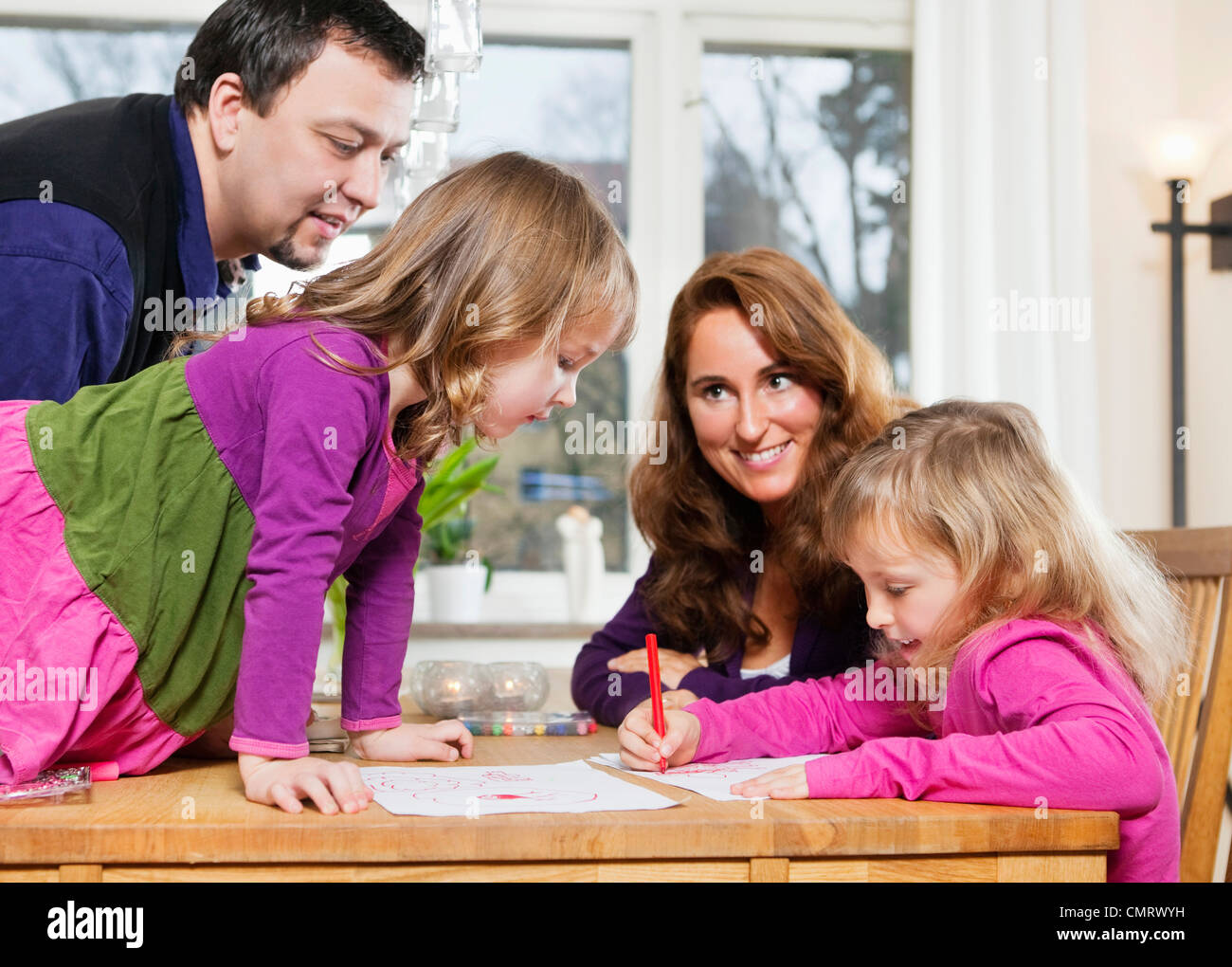 Family by kitchen table Stock Photo - Alamy