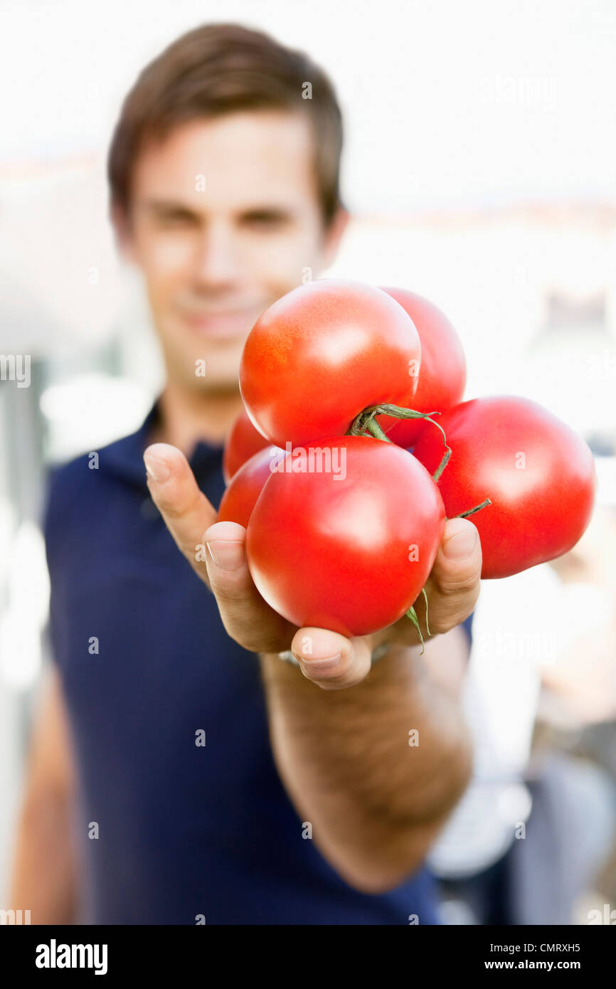 Man holding out tomatoes Stock Photo - Alamy