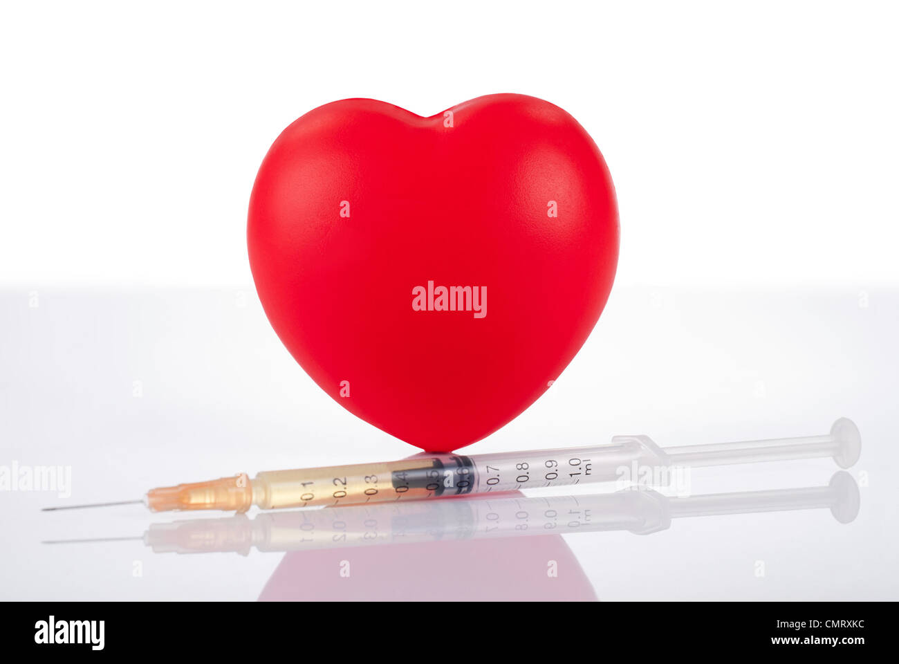 Syringe with heart next to it. Studio shot with reflection Stock Photo ...