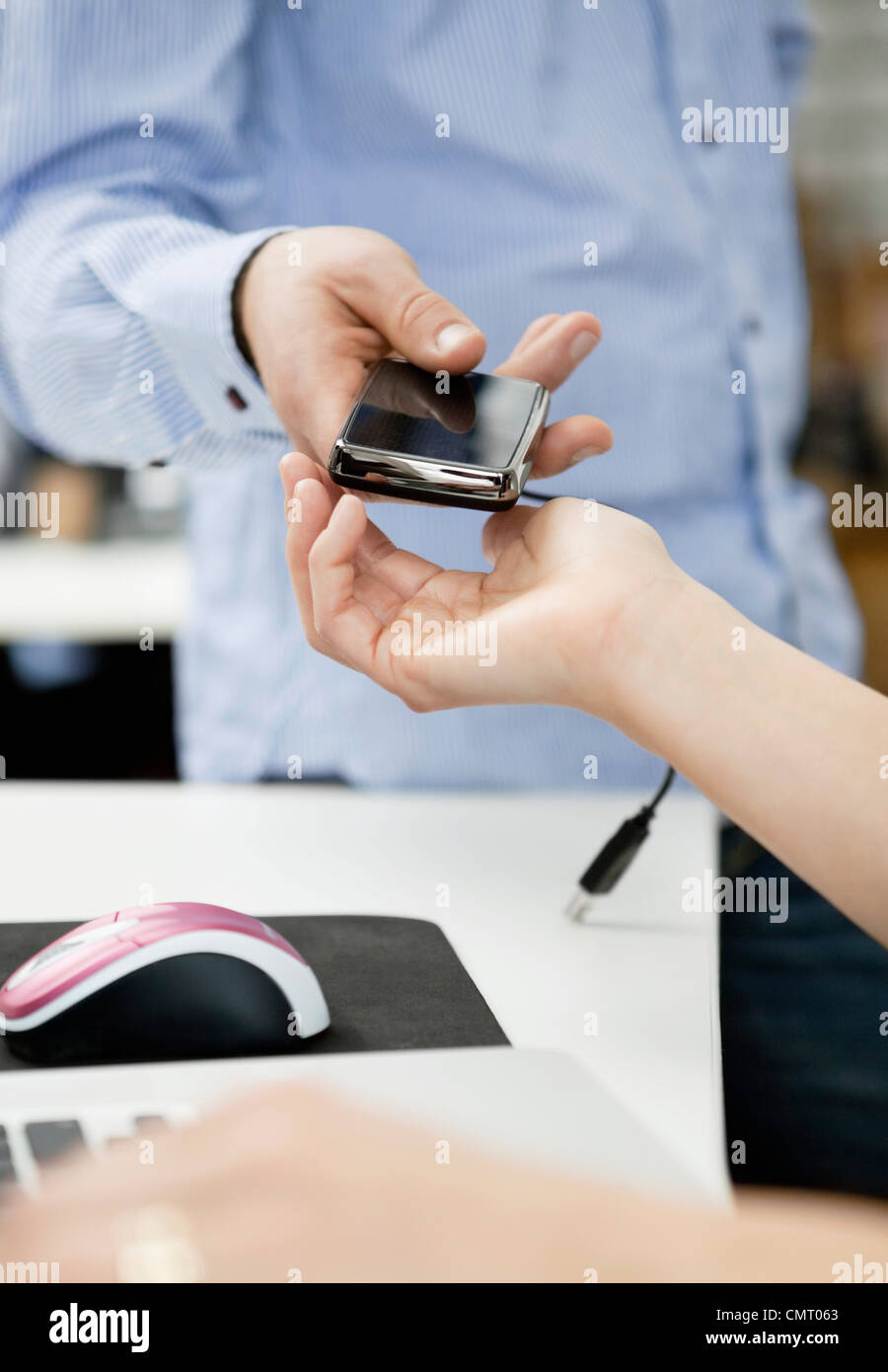 Man giving cellphone to the woman Stock Photo - Alamy