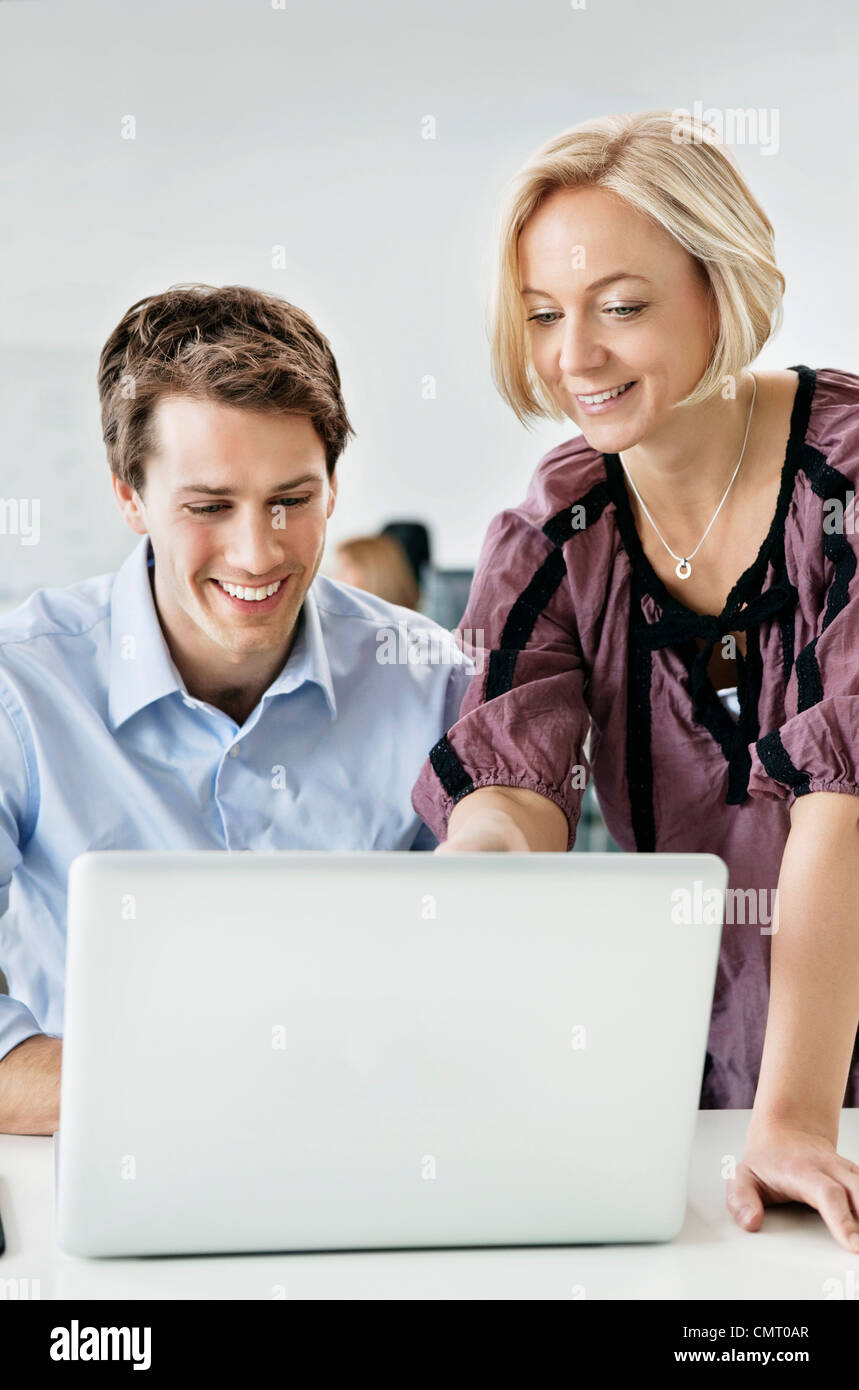 Two people using laptop and smiling Stock Photo - Alamy